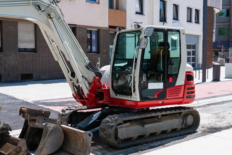 A Small Red Excavator Next To a Pile of Gravel at a Construction Site ...