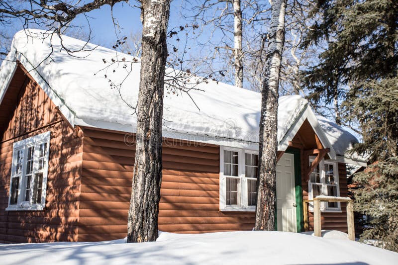 A Cabin with a Green Door and White Windows Sits in the Snow Stock ...