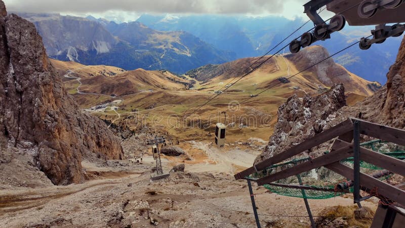 Cable Car Descending Steep Cliff in Dolomites with Mountain Valley in ...