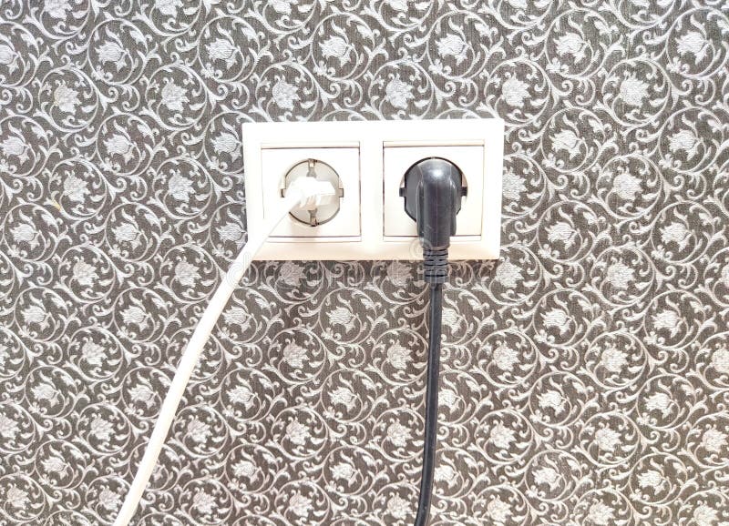 Cables Connected To Power Sockets Against a Decorative Wall. Dual ...