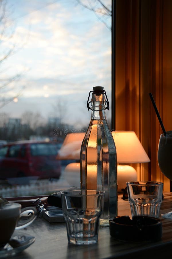 Cafe Atmosphere at Golden Hour. Water Glass Bottle Stock Image - Image ...