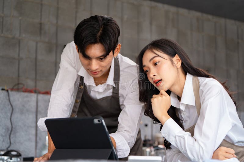 Cafe Team Analyzing Performance on a Tablet in a Stylish Workspace ...