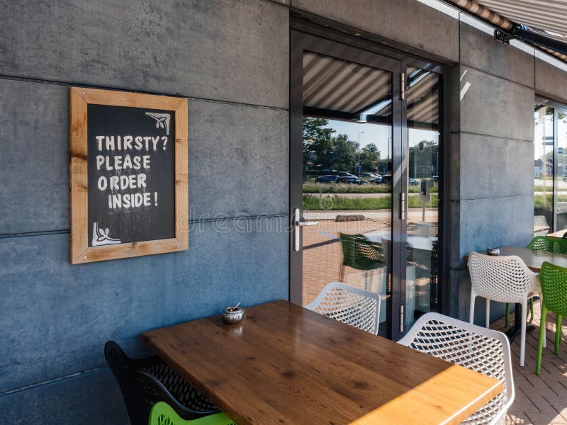 Cafe Terrace with Thirsty Please Take an Order Inside Sign Stock Image ...