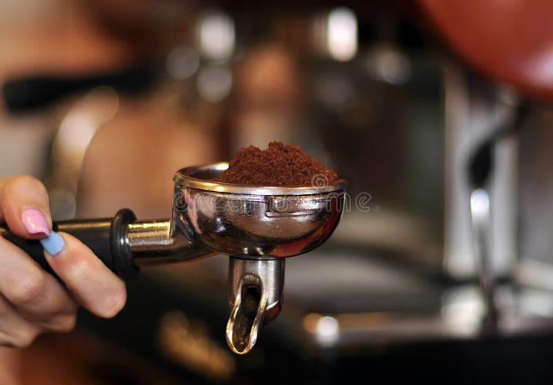 A Cafe Worker Brings Freshly Ground Coffee To a Coffee Machine. Stock ...