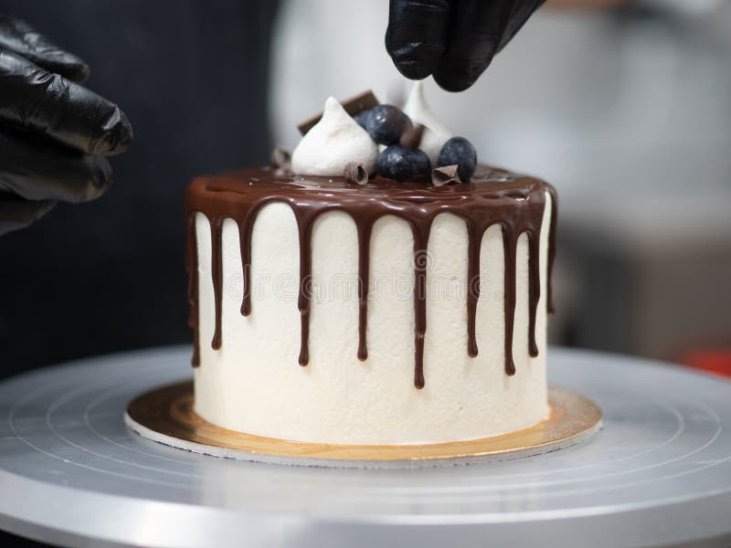 Cake Designer Decorating a Chocolate Drip Cake with Meringue and ...