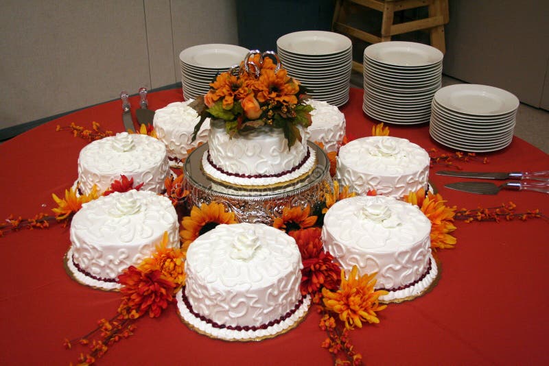 Cake Place Setting on Round Table with Red Table Cloth and Stacks of ...