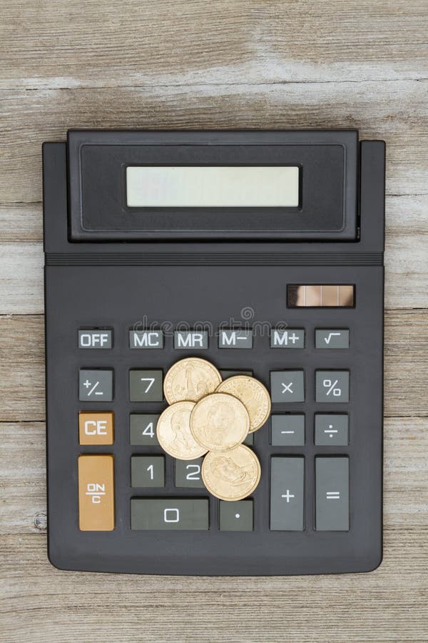 Calculator with a Gold Dollar Coin on Weathered Wood Stock Photo ...