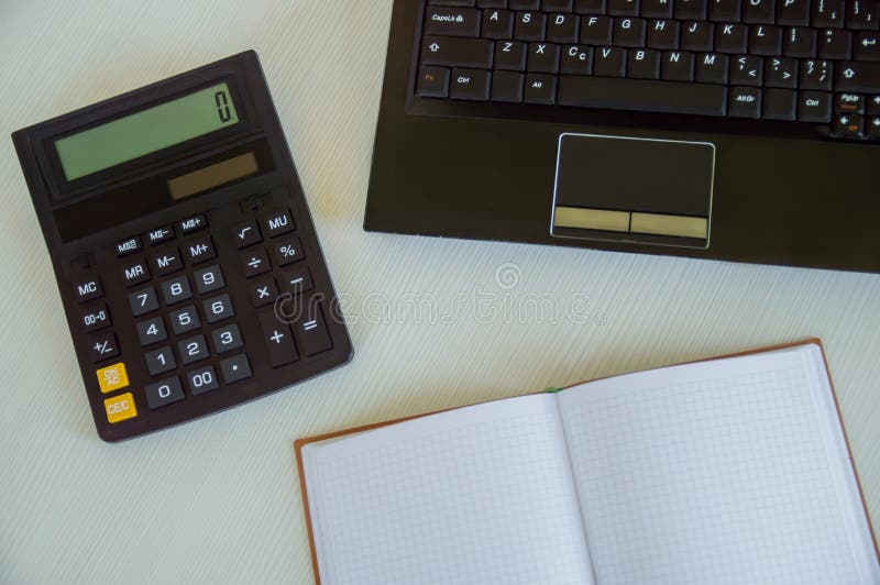 Calculator, Laptop and Notepad are on the White Table. Office Items ...