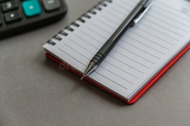 Calculator, Pen, Notepad Lie on a Gray Surface. Open Spring-loaded ...