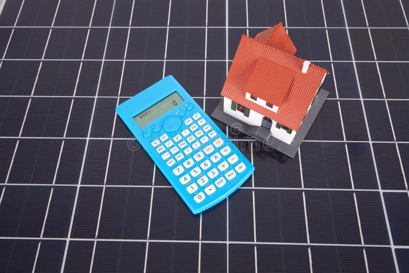 Calculator and Small House Model on Solar Panel Background Stock Photo ...
