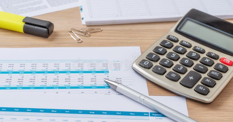 A Calculator and Some Paperwork on a Desk Stock Photo - Image of ...