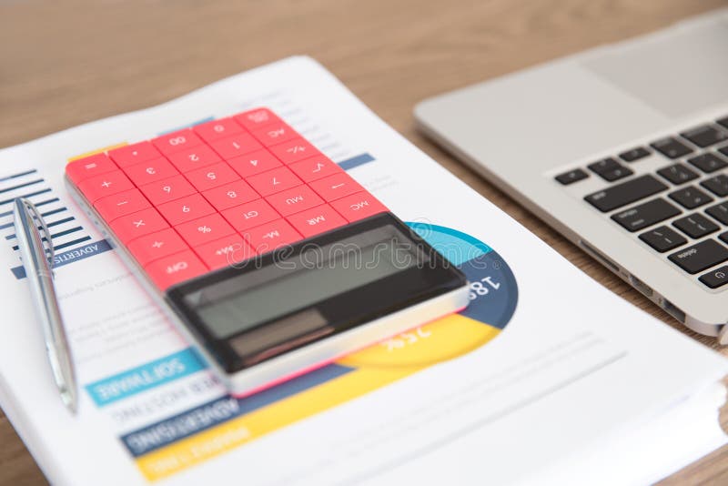 A Calculator on a Stack of Documents and a Computer Next To it Stock ...