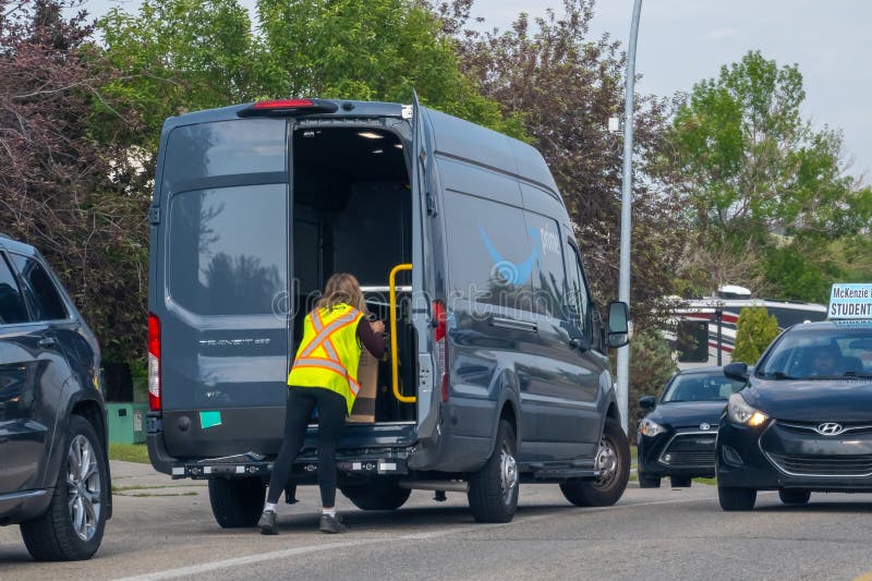A Candid Street Shot Shows a Delivery Worker Loading Packages into an ...