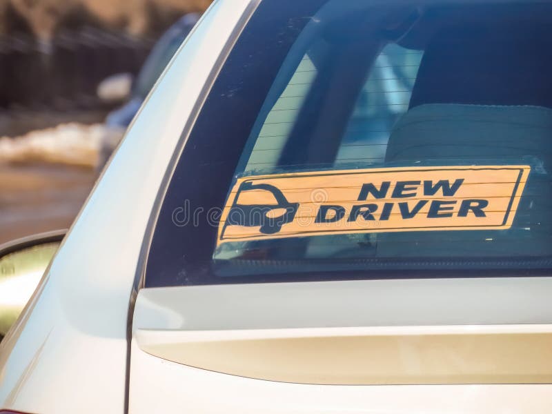 A Close-up of a Sign Reading "new Driver" Placed on the Back Window of ...