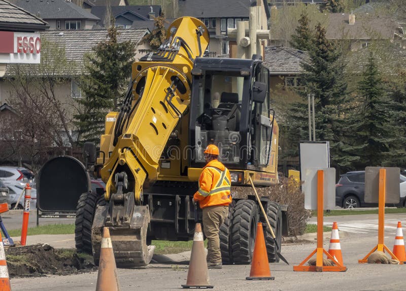 A Construction Worker with a Backhoe Loader Extendible Dipper Deere ...