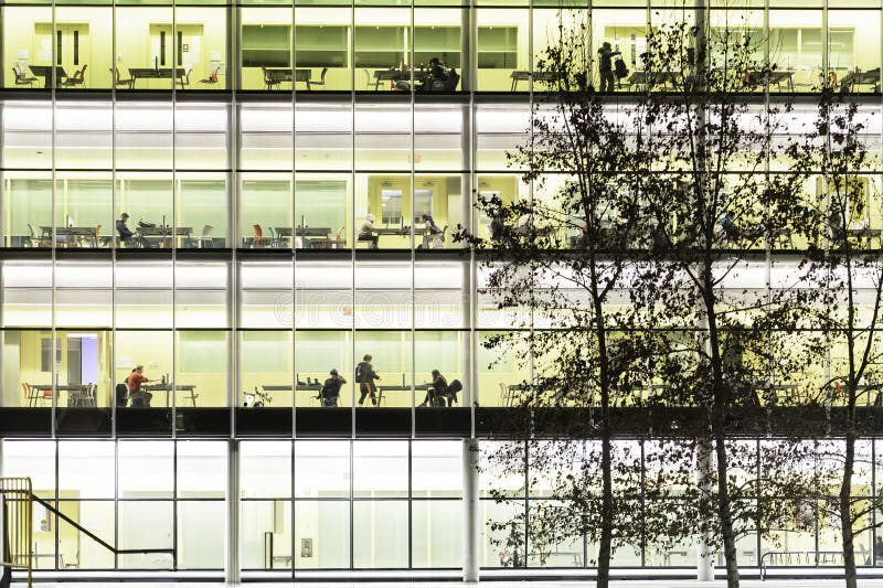 Students Studying at Night with Glass Windows Overlooking a Square with ...