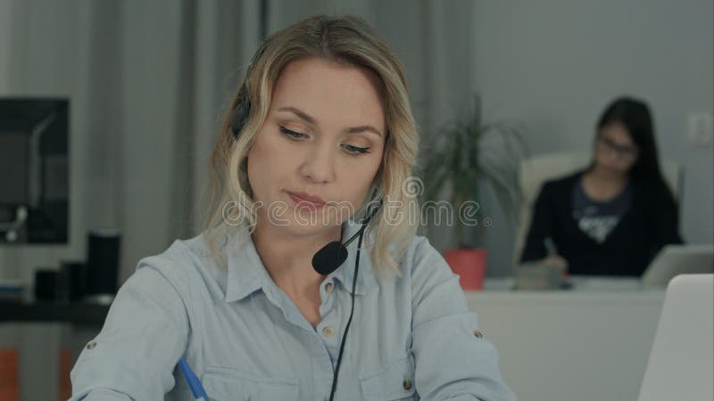 Call Center Employee Making Notes while Talking with Customer Stock ...