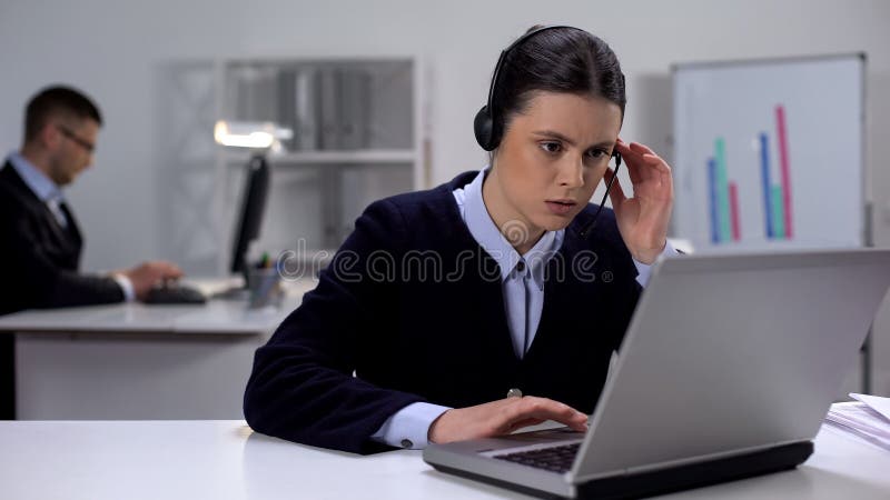 Call Center Manager in Headset Checking Data on Laptop, Customer ...