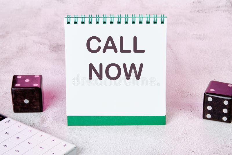 Call Now Text on a White Notepad Sheet Next To Dice on an Abstract ...