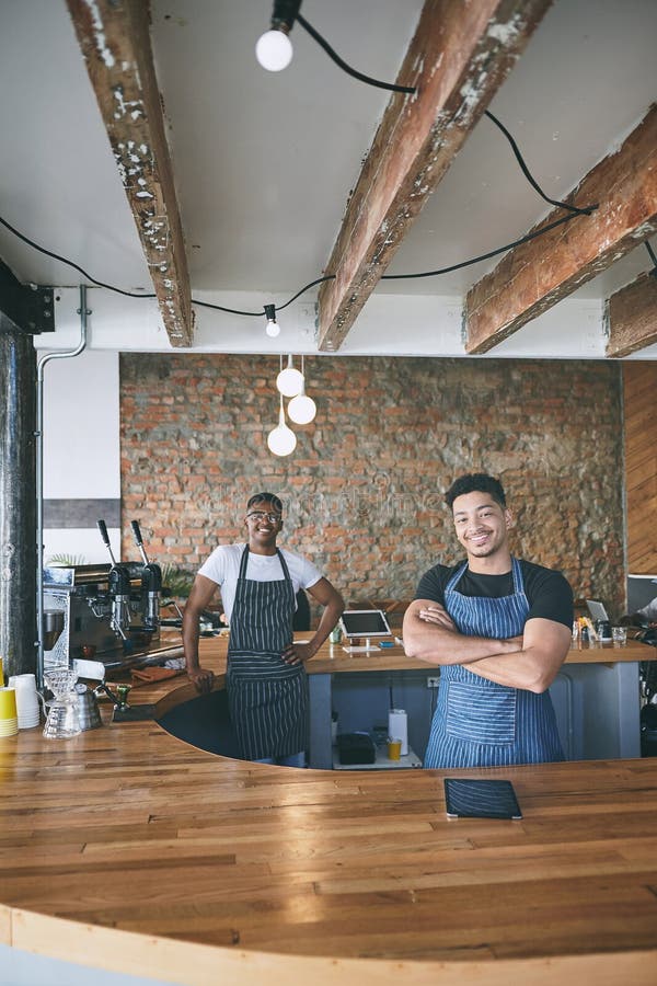On Call To Bring You Great Coffee. Two Confident Young Men Working in a ...