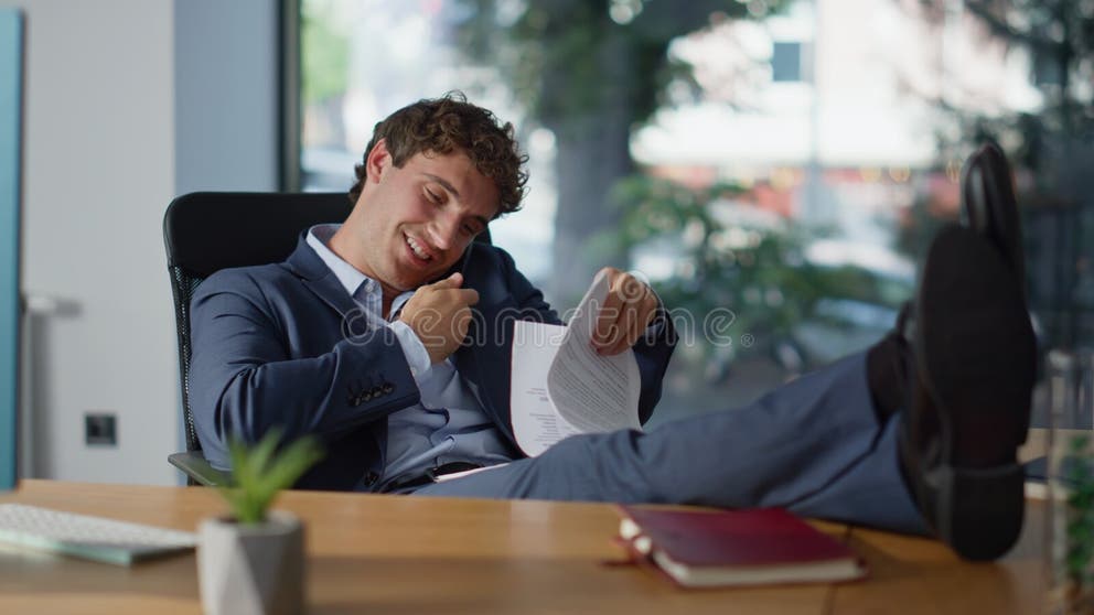 Calling Executive Reading Documents Sitting Office with Legs on Table ...