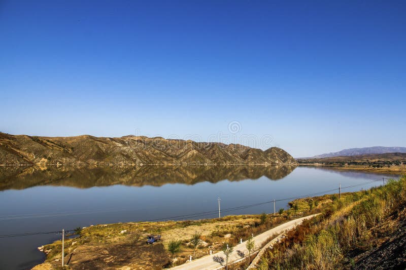 The Calm Blue Lake Reflects the Blue Sky and Mountains Stock Photo ...