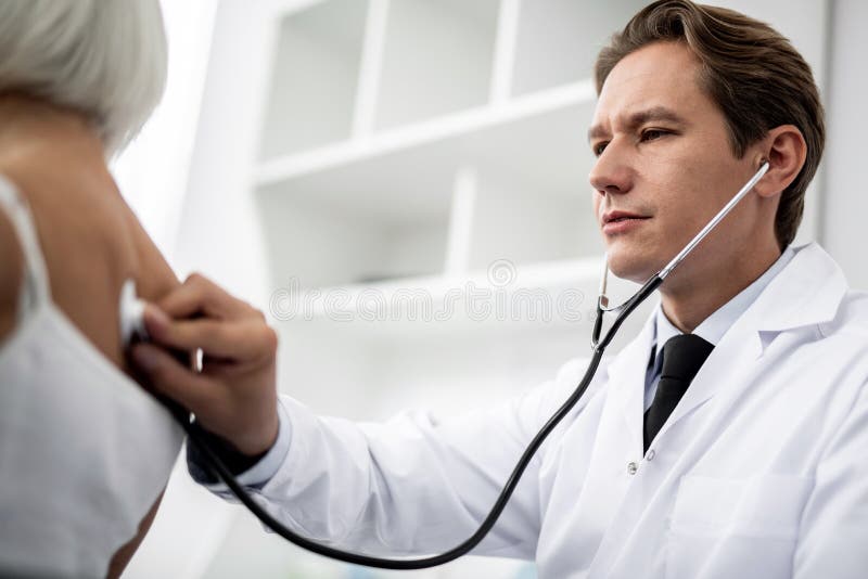 Calm Doctor Putting Stethoscope on the Back of His Patient Stock Image ...
