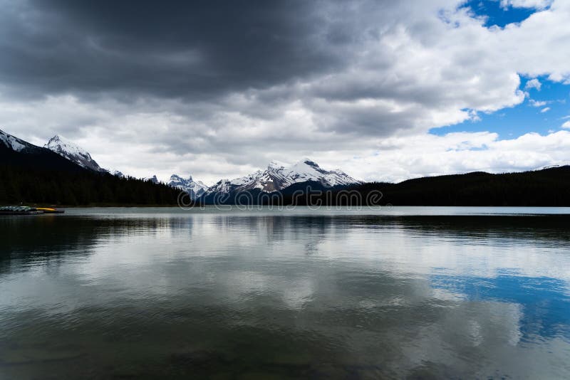 Calm Lake with the Snowy Mountains in the Background and Cloudy Sky ...
