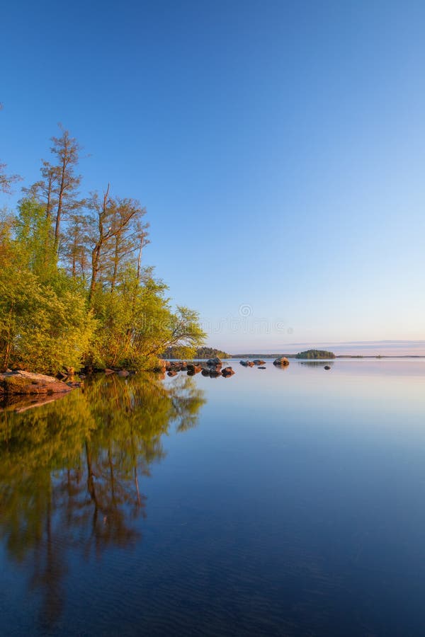 Calm lakeside at sunset stock photo. Image of lakefront - 112158036