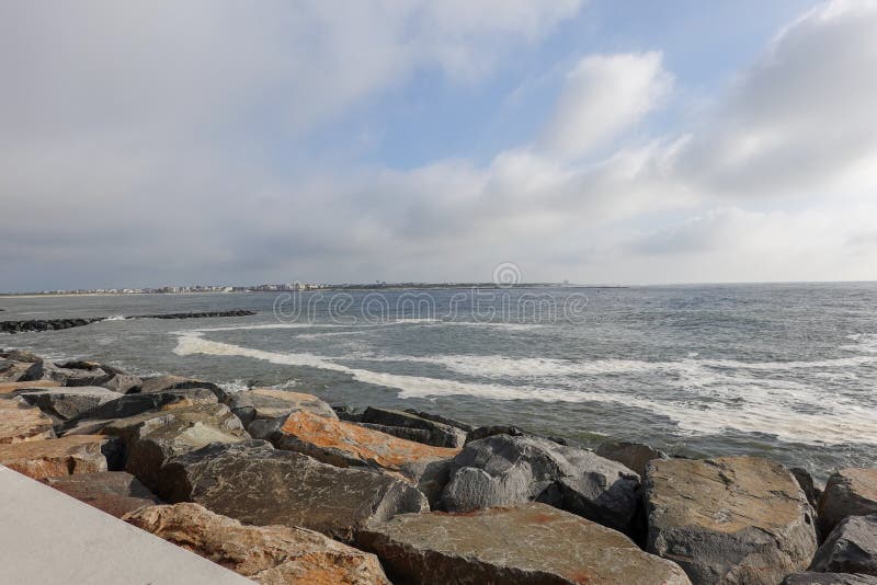 Calm Ocean Inlet with Boulder Jetty As Dark Storm Clouds Approach Stock ...