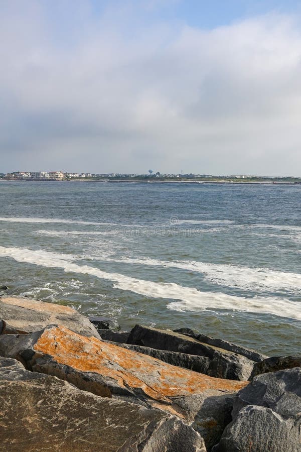 Calm Ocean Inlet with Boulder Jetty As Dark Storm Clouds Approach Stock ...