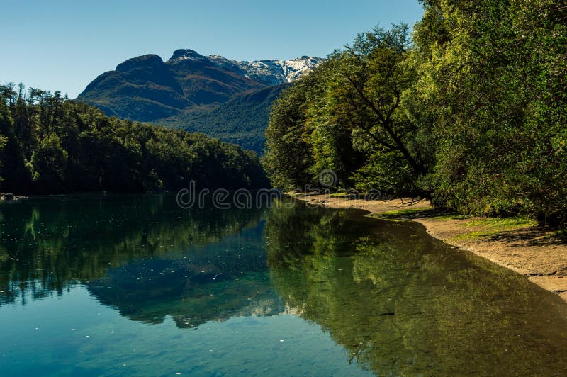 Calm River Reflecting the Forest and a Mountain Range in the Background ...