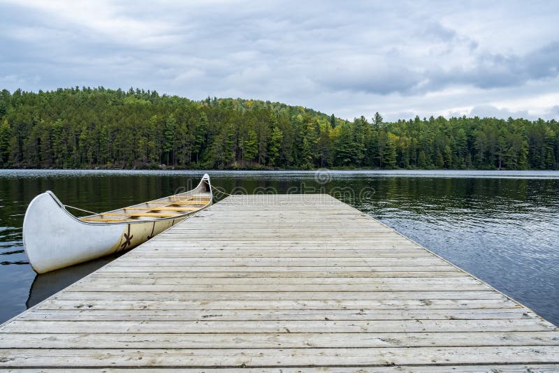 Calm Scene of a Canoe Parked beside a Dock in a Lake #2 Stock Image ...