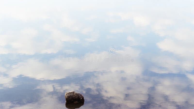 Single Stone in Calm Water with Reflecting Clouds Stock Image - Image ...
