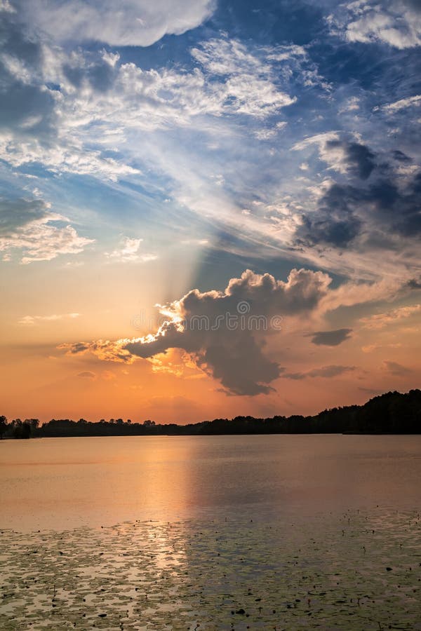 Calm Sunset at Lake with Sun Rays in Clouds Stock Photo - Image of boat ...