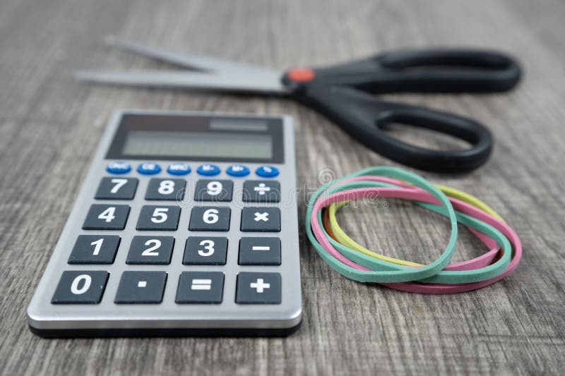 A Calculator Isolated on a Wooden Desk with Rubber Bands and Scissors ...
