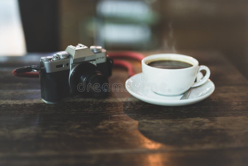 Camera and Coffee Cup on Wooden Table in the Morning. Stock Image ...