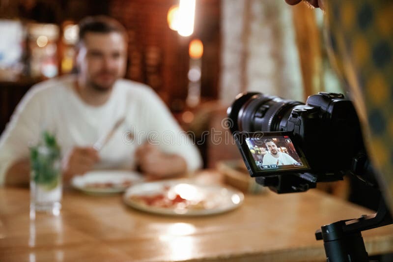 Camera is Filming Him. Man is Sitting in the Restaurant and Eating a ...