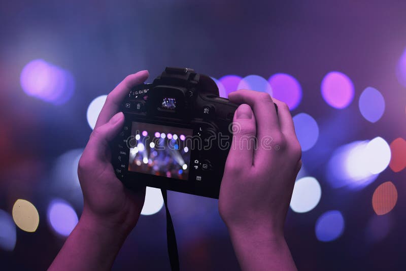 Camera in Hands. Bokeh and Concert, Live Music Lights in Background ...