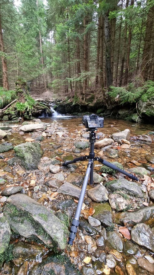 A Camera Mounted on a Tripod is Positioned on a Rocky Streambed ...