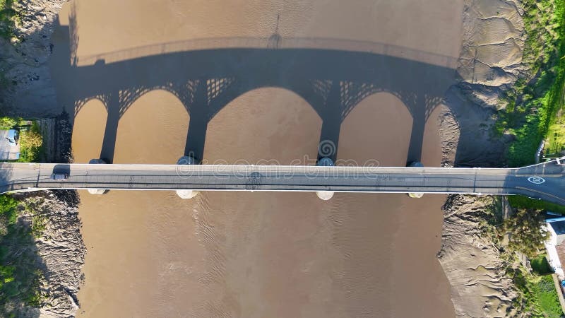 Camera Panning Over Bridge Casting Shadow on River at Low Tide Stock ...