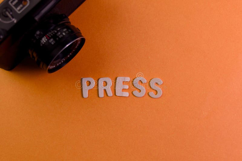 Camera and Press Letters on an Orange Backdrop Stock Photo - Image of ...