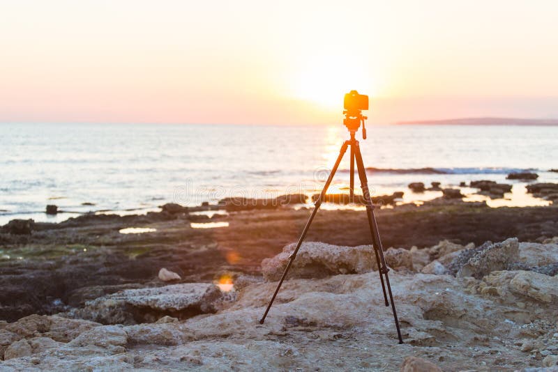 Camera with Tripod Over Sun Rising Near the Beach Stock Photo - Image ...