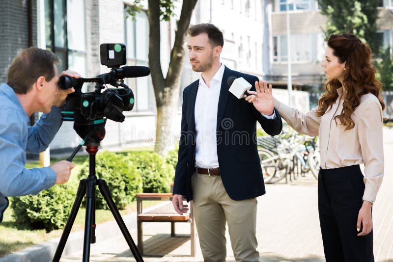 Cameraman and News Reporter with Microphone Interviewing Businessman ...
