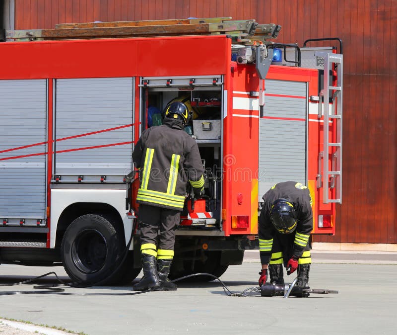 Camion Dei Vigili Del Fuoco E Pompieri Con Le Uniformi Fotografia Stock ...