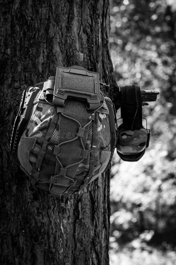 Camouflage-patterned Military Tactical Helmet Hangs on a Tree Branch in ...