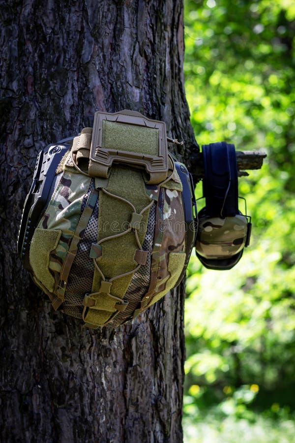 Camouflage-patterned Military Tactical Helmet Hangs on a Tree Branch in ...