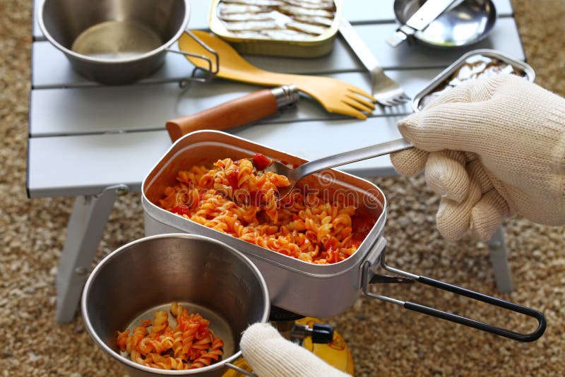 Camp Food. Making a Tomato Pasta Dish in Mess Tin and Serving it. Stock ...