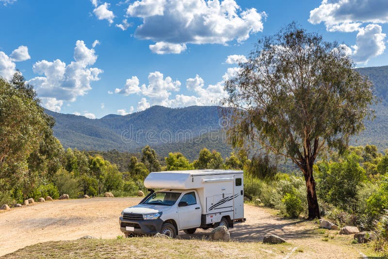 A Camper Parked Under a Tree at a Scenic Campsite in the Mountains ...