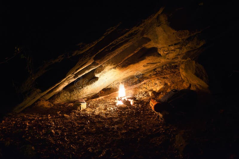 Bonfire in a Cave Surrounded by Rocks and Branches during the Rain ...